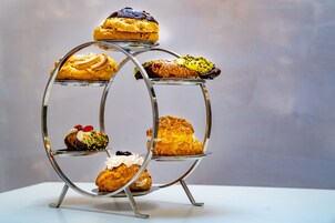 Suporte de metal em três níveis com diversos doces.