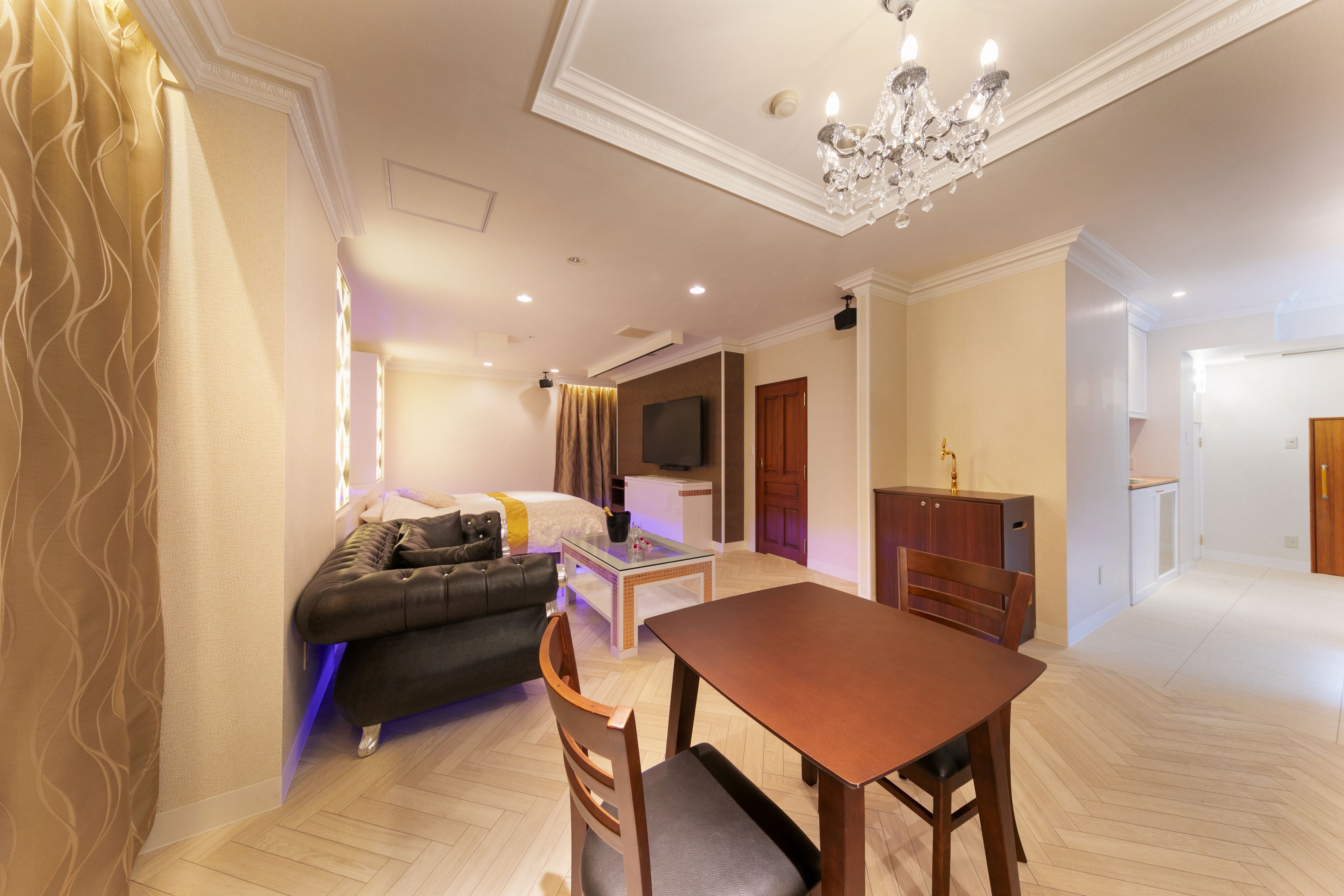 Uma sala de estar moderna com sofá, mesa de jantar e televisão.