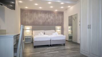 Quarto moderno com uma cama grande, abajures, televisão e guarda-roupa.