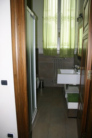 Apartamento, 2 quartos | Casa de banho | Um polibã, artigos de higiene pessoal grátis, toalhas fornecidas 