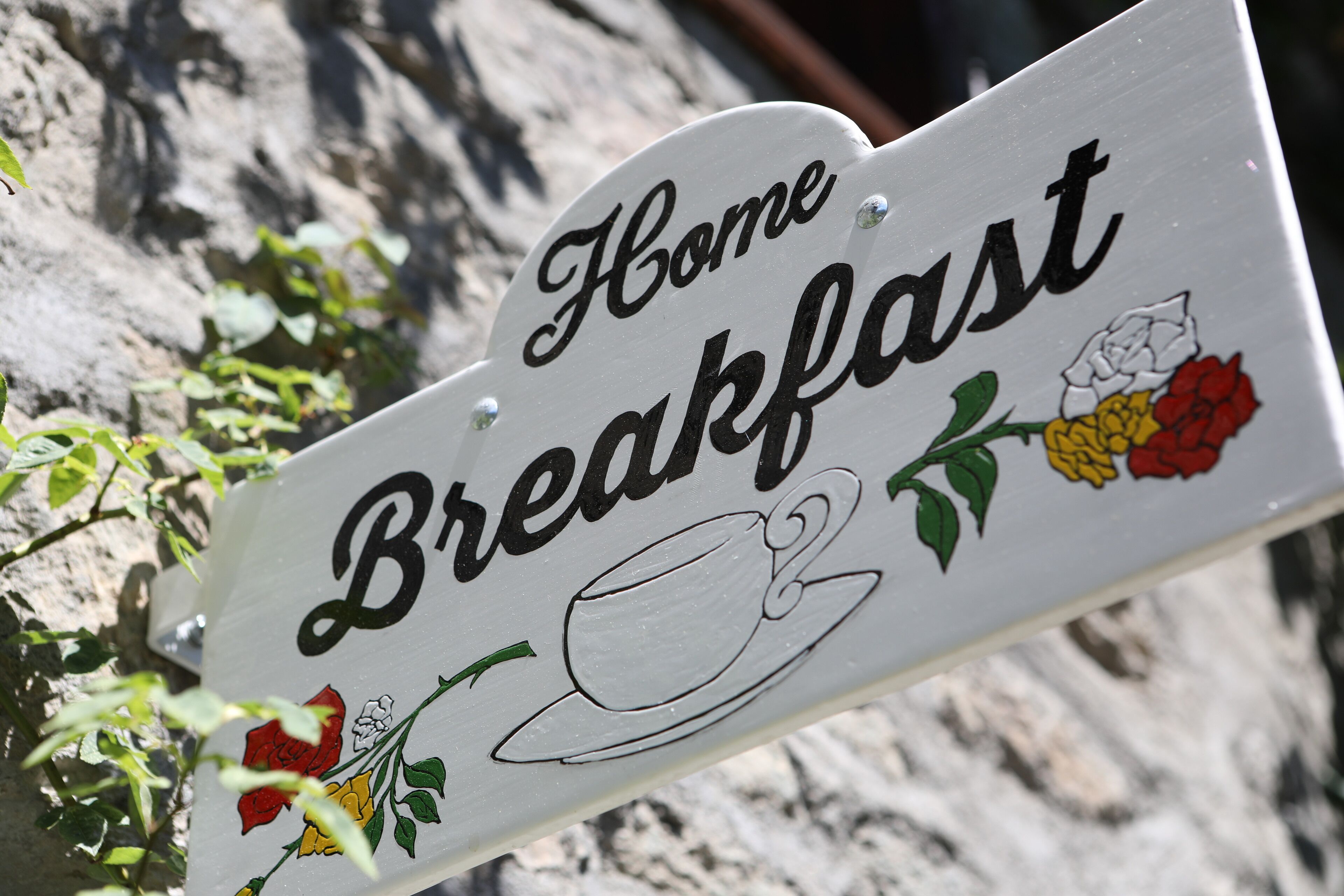 Um letreiro com o texto 'Home Breakfast' e uma ilustração de uma xícara de café.