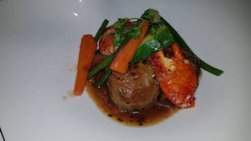 Um prato de comida com carne, cenouras e vegetais verdes.