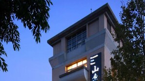 Hotel com design moderno, destacando uma placa com caracteres japoneses e a palavra 'Resort'.