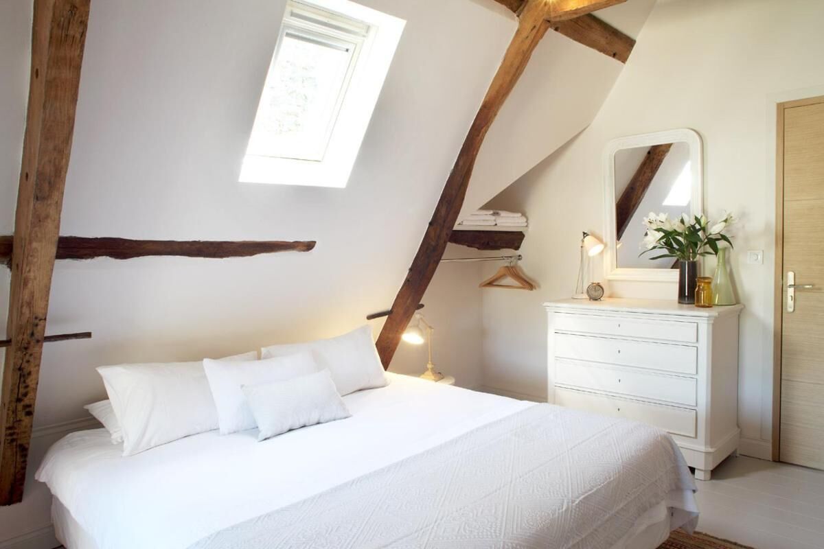 Quarto com cama, penteoude e espelho.