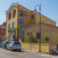 Um edifício amarelo com a placa Hotel Maria e um mercado Fasolino.