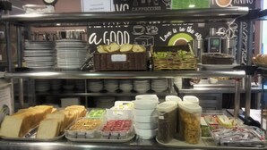Um buffet de café da manhã com diversas opções de alimentos e acompanhamentos.