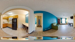 Vista panorâmica de um apartamento moderno com cozinha, sala de jantar e sala de estar.