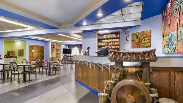 Um restaurante com balcão, cadeiras e mesas.