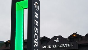 Placa para Muju Resort com uma seta iluminada em verde apontando para a direita, indicando o caminho para o estacionamento.