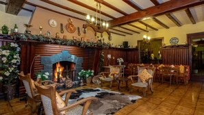 Um quarto aconchegante com lareira de pedra, móveis de madeira e diversos objetos decorativos.