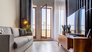 Uma sala de estar moderna com um sofá, uma televisão e um armário de madeira.