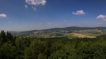 Vista panorâmica de uma cidade aninhada num vale, com colinas ondulantes ao fundo.