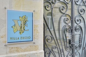 Um letreiro com um logotipo e o nome 'Villa Erizzo' em uma parede.