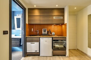 Uma cozinha compacta com máquina de lavar louça embutida, forno e máquina de café.