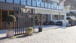Hotel com fachada moderna, área de recepção e espaço ao ar livre para sentar.