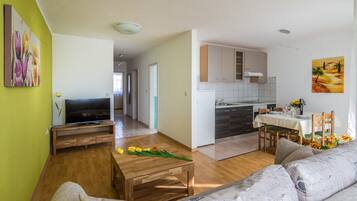 Apartamento Comfort em Condomínio Fechado, 2 quartos, acesso à piscina, vista parcial para o mar | Sala de estar | TV de ecrã plano