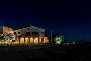 Um edifício moderno de dois andares com fachada branca e várias janelas em arco.