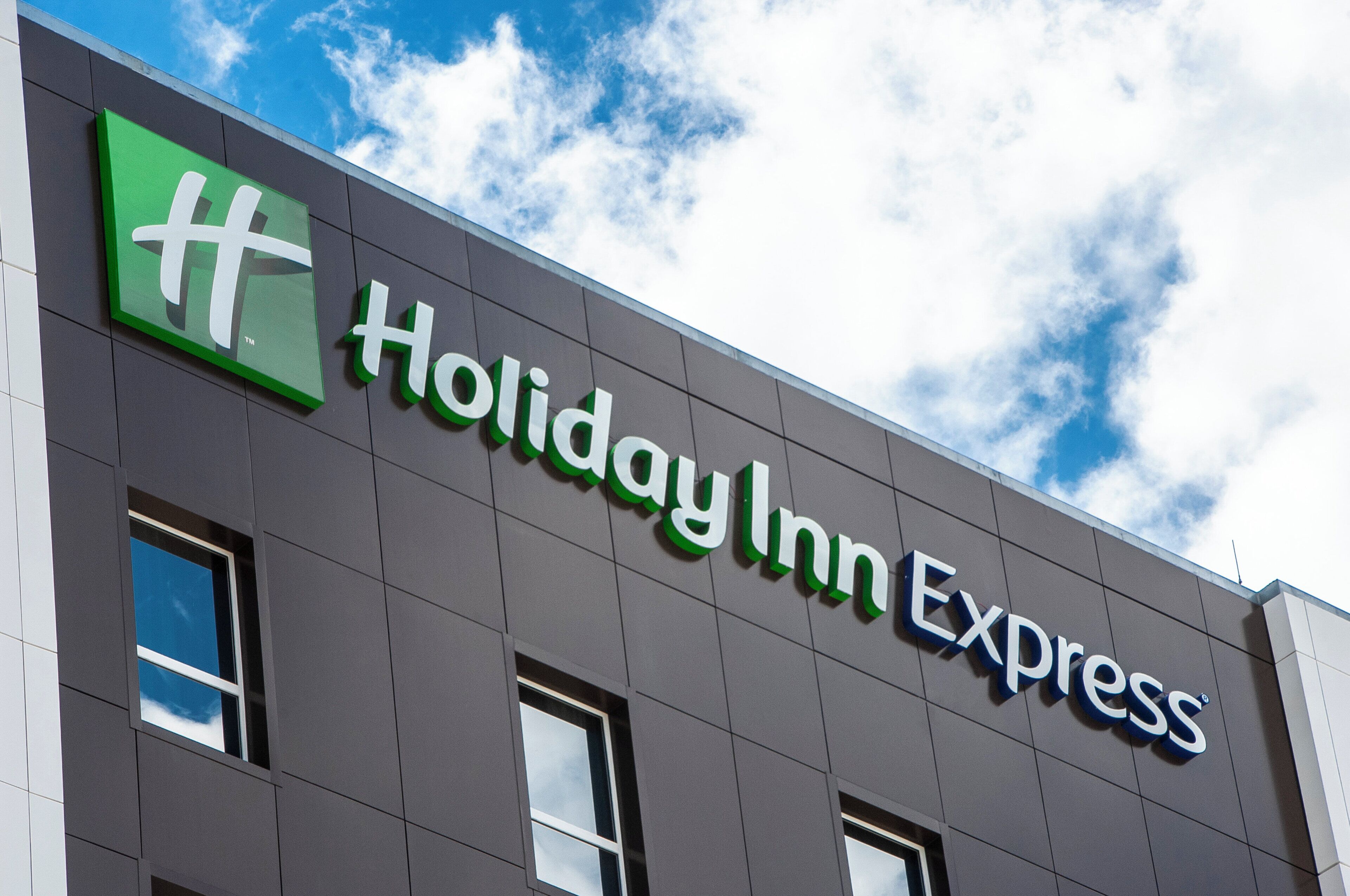 Edifício Holiday Inn Express com céu azul ao fundo.