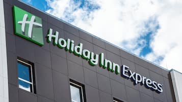 Edifício Holiday Inn Express com céu azul ao fundo.
