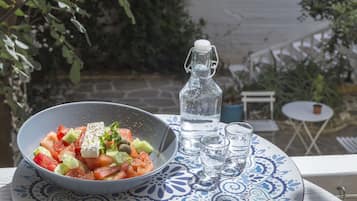 Uma mesa com uma saladeira, uma garrafa de água e dois copos.