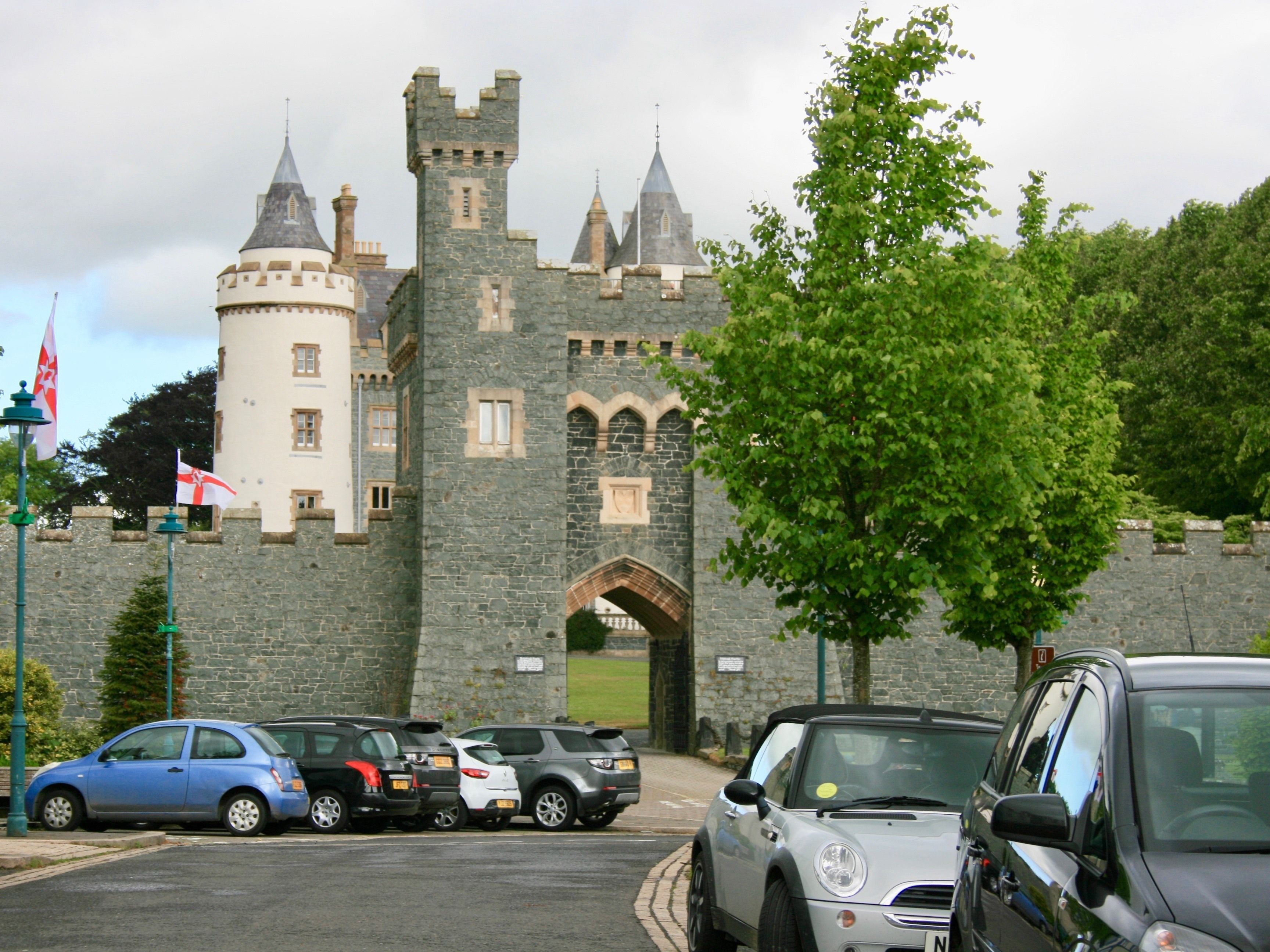Um edifício semelhante a um castelo, com fachada de pedra, várias torres e um arco central.