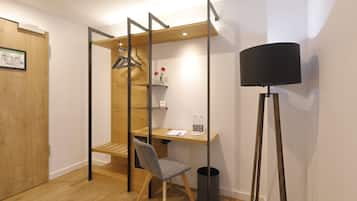 Quarto compacto com escrivaninha, cadeira e abajur.