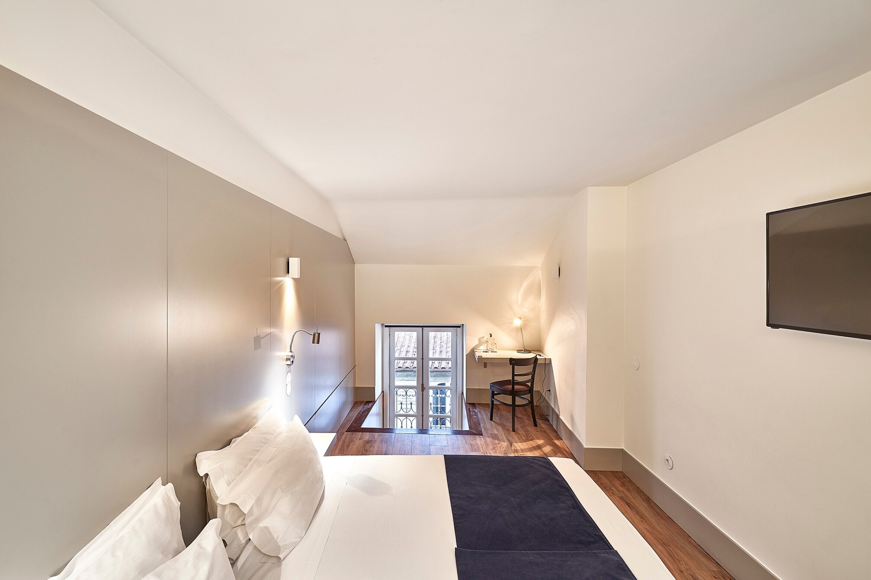 Quarto com uma cama, uma escrivaninha e uma cadeira.