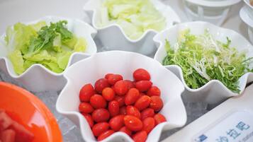 Diversos alimentos em tigelas brancas sobre uma mesa.