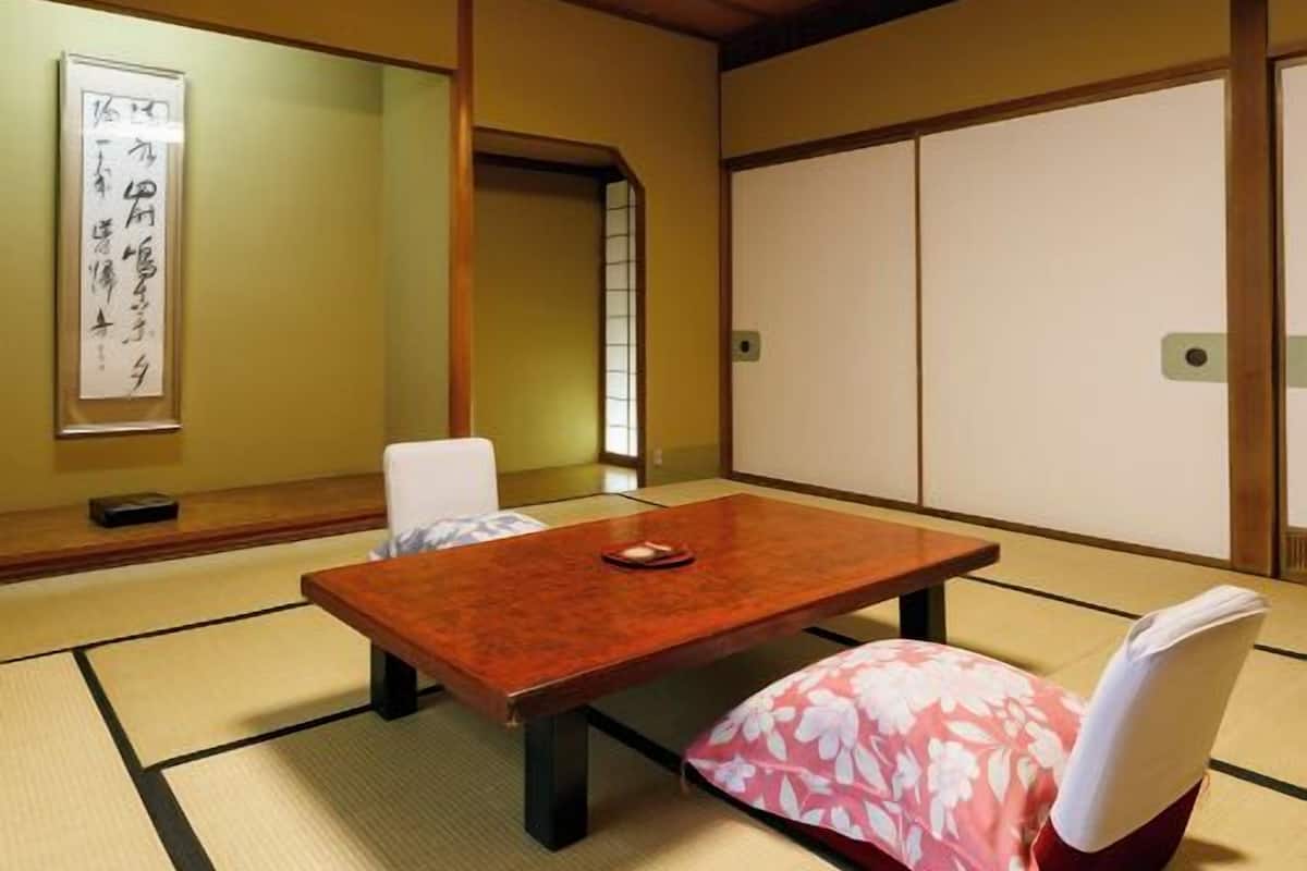 Um quarto japonês tradicional com tatames, uma mesa baixa e uma porta de papel shoji.