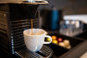 Máquina de café servindo café numa chávena branca.