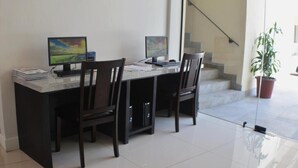 Uma área de refeições com dois monitores de computador, uma mesa e quatro cadeiras.
