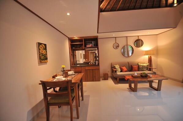 Uma sala de estar moderna com sofá, mesa de centro e área de jantar.