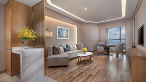 Uma sala de estar moderna com uma ilha de mármore, um sofá e uma área de jantar.