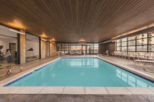 Piscina com espreguiçadeiras e equipamentos de ginástica.