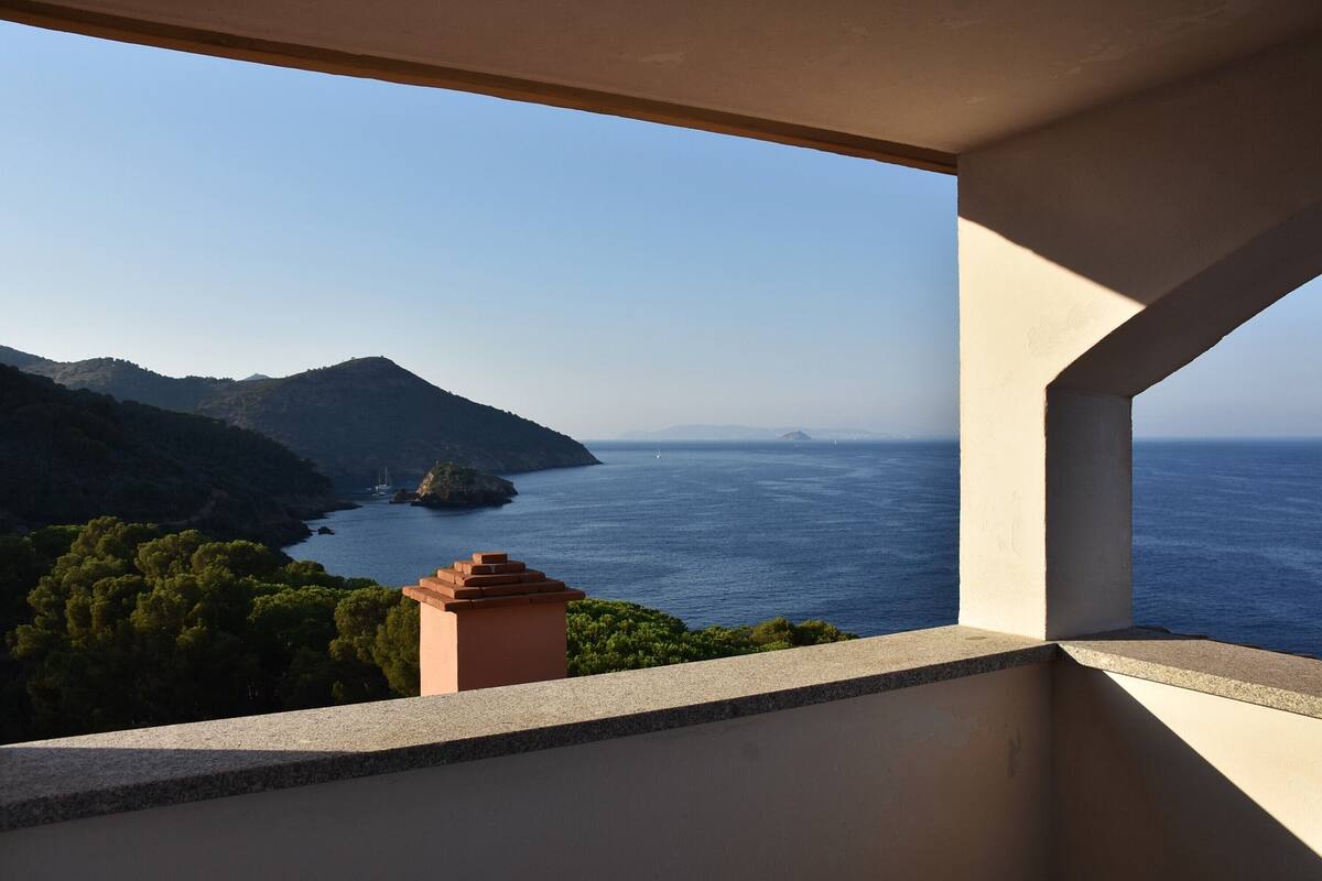 Uma varanda com vista para o mar e montanhas.
