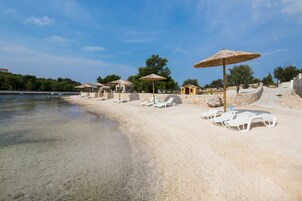 Uma praia privada, espreguiçadeiras, guarda-sóis de praia 