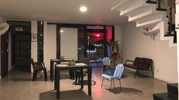 Uma sala de estar ampla com mesa e cadeiras de jantar, escada e vista para o exterior.