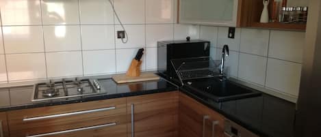 Apartamento conforto, 2 quartos | Cozinha privada | Geladeira, micro-ondas, fogão, cooktop