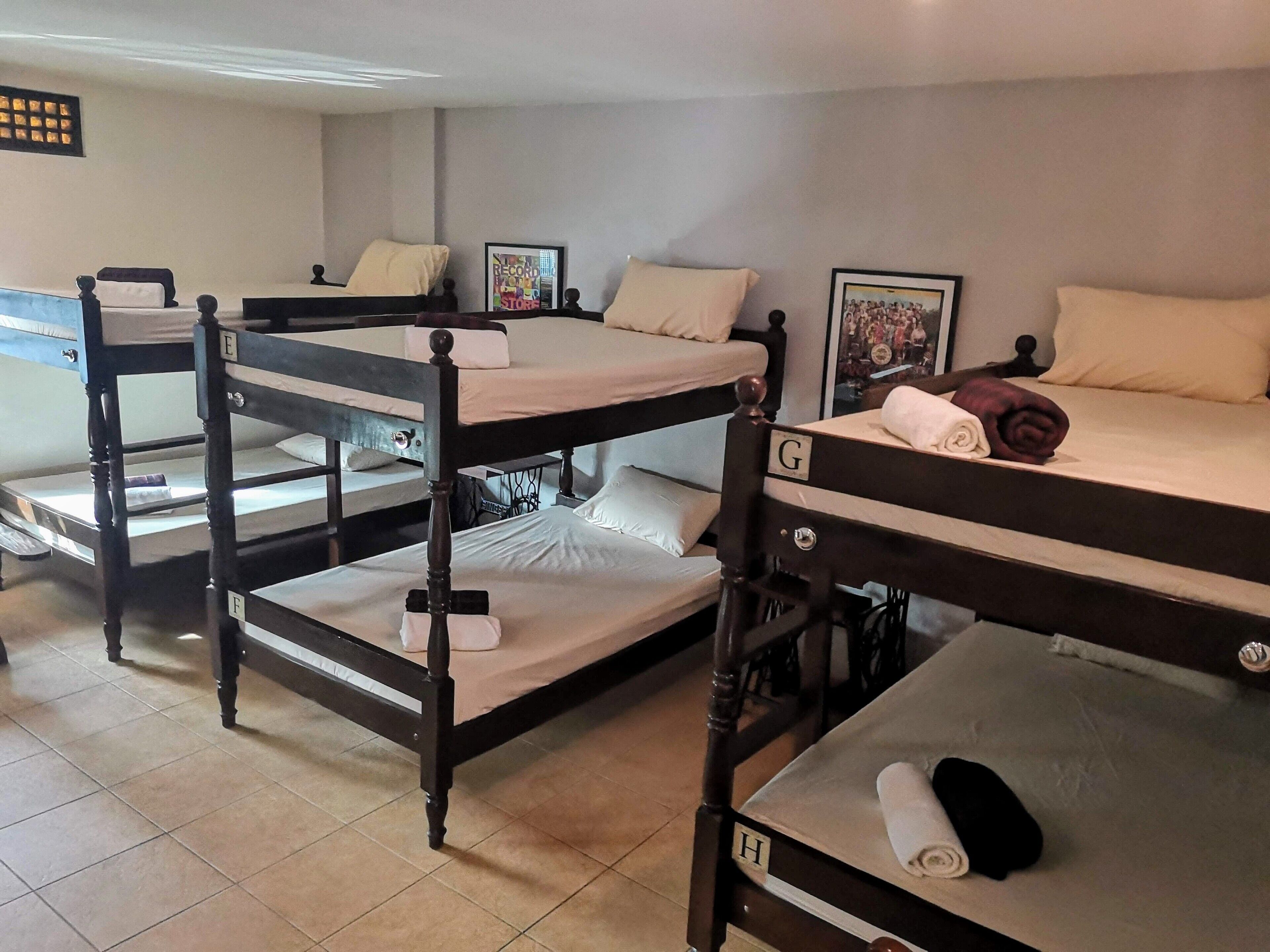 Quarto tipo dormitório com beliches identificados pelas letras E, F, G e H.
