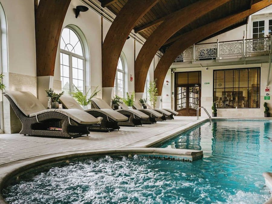 Uma área de piscina com espreguiçadeiras e uma banheira de hidromassagem.