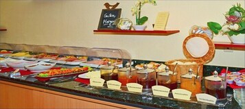 Buffet com diversas opções de comida e máquinas de bebidas.