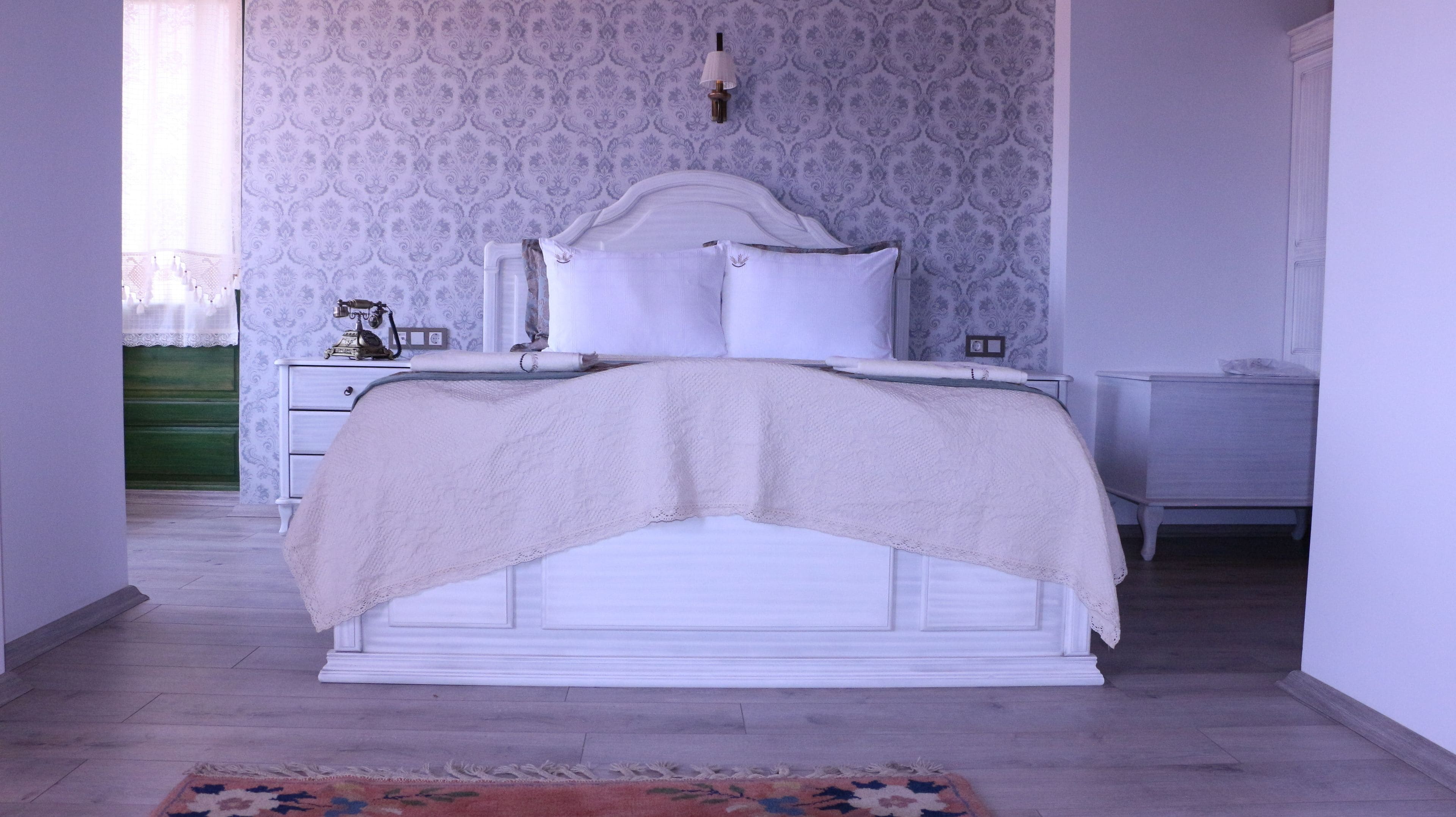 Quarto com uma cama grande, cômoda e mesa de cabeceira.