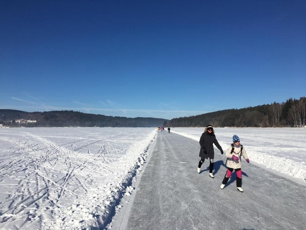 Um lago congelado com pessoas patinando no gelo.