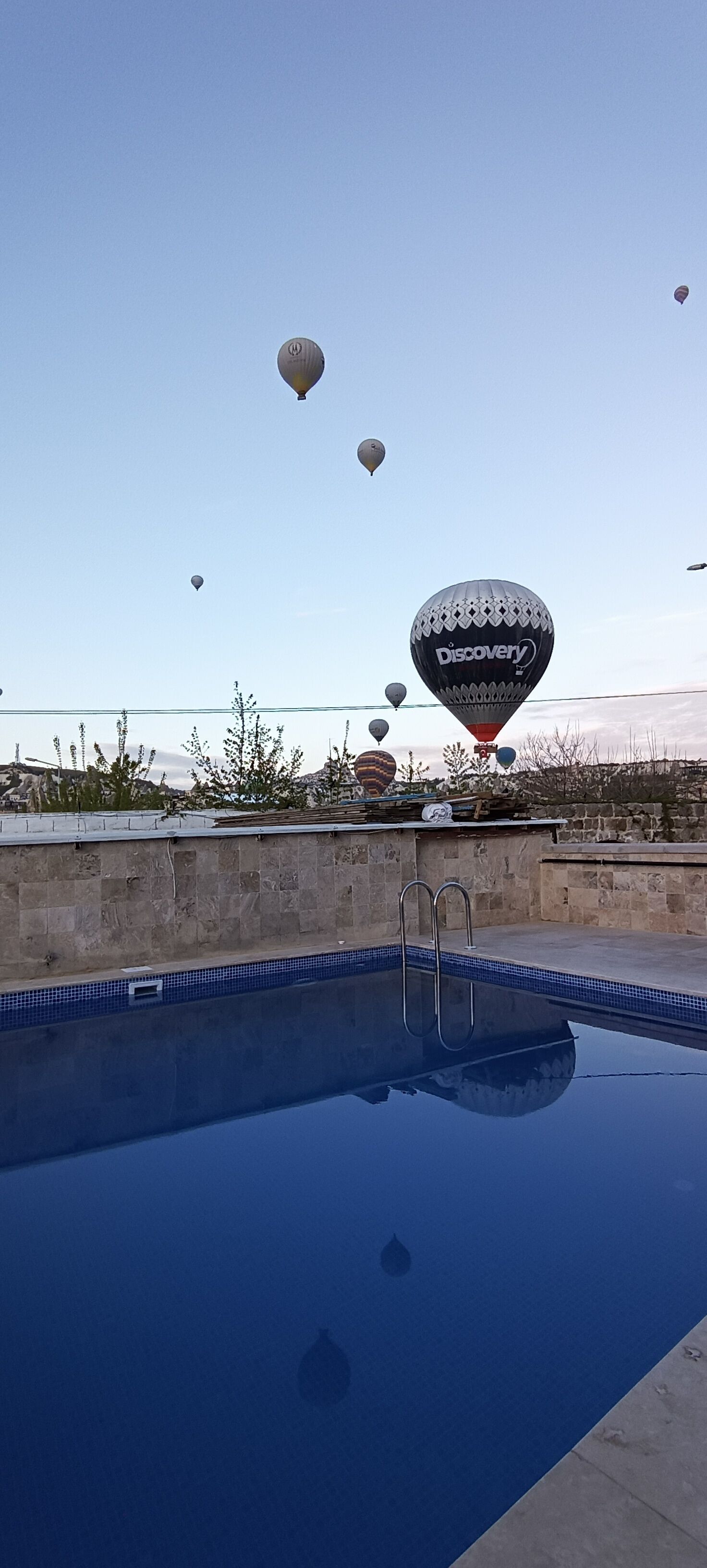 Uma piscina com balões de ar quente ao fundo.