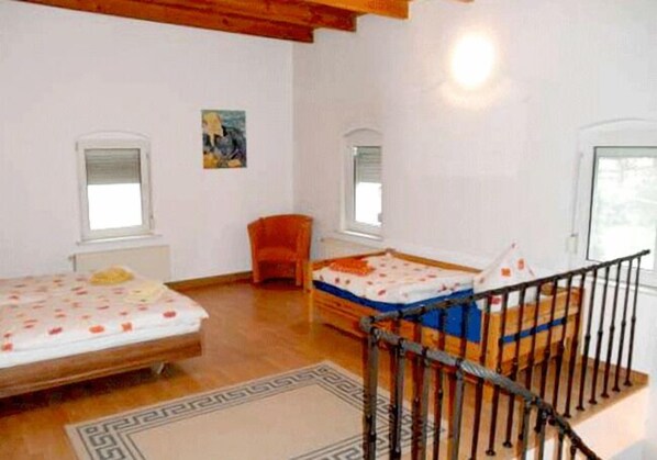 Um quarto com uma cama, uma cadeira e uma escada.