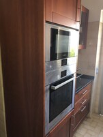 Um frigorífico, um micro-ondas, um forno, uma placa de cozinha 