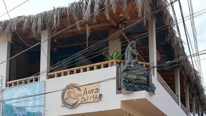 Um edifício de dois andares com uma placa que diz 'Casa Aura Del Mar'.