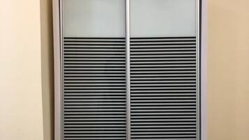 Quarto com porta de vidro deslizante e painel de parede ventilado.
