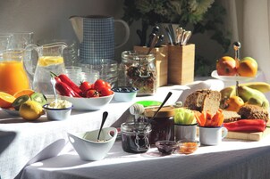 Uma mesa de café da manhã com diversos alimentos e bebidas.