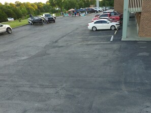 Um estacionamento com vários carros e um barco.